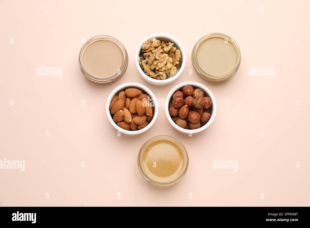 Different types of delicious nut butters and ingredients on beige ...
