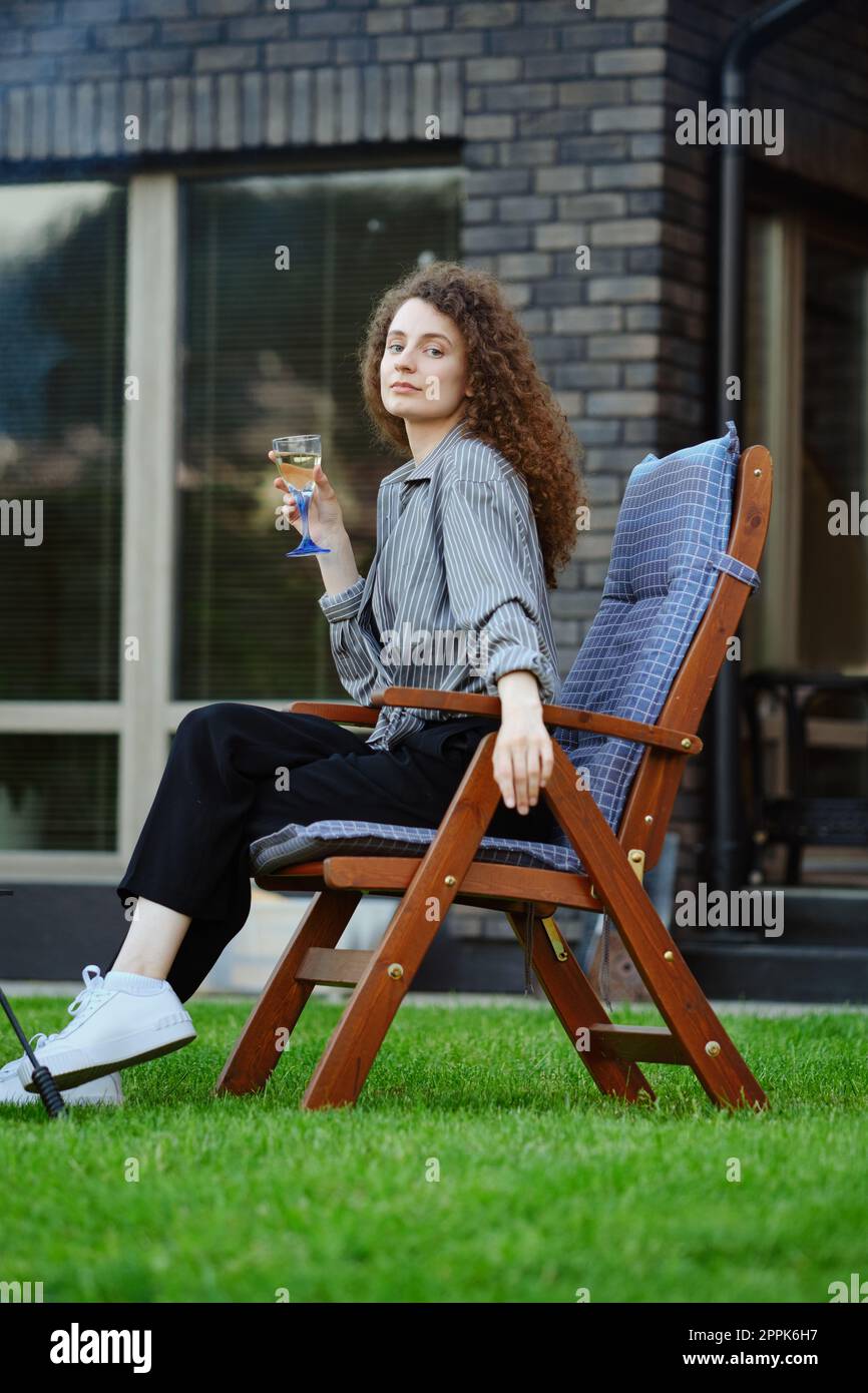 Woman sits on green grass hi-res stock photography and images - Alamy