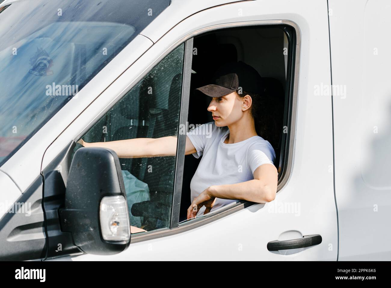 Female driver in white uniform driving a van Stock Photo - Alamy