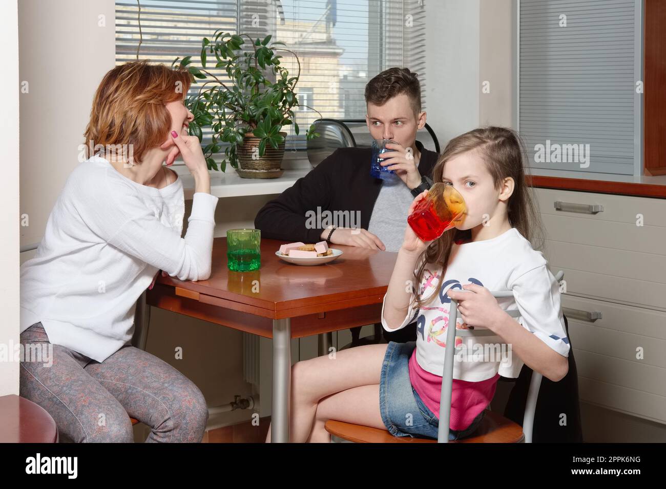 family on the kitchen behind the table Stock Photo - Alamy
