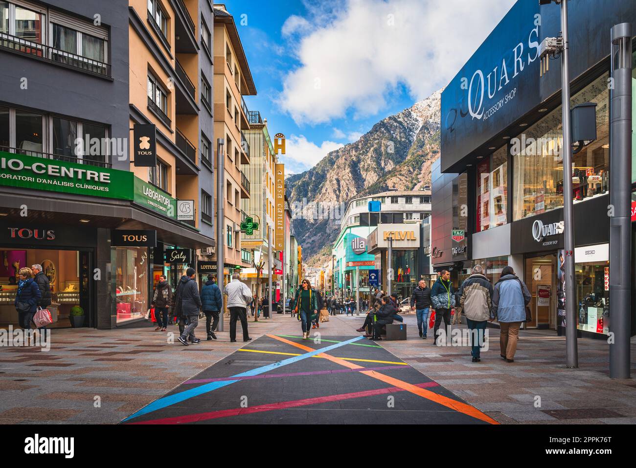 People walking and shopping on promenade with Pyrenees Mountains in ...