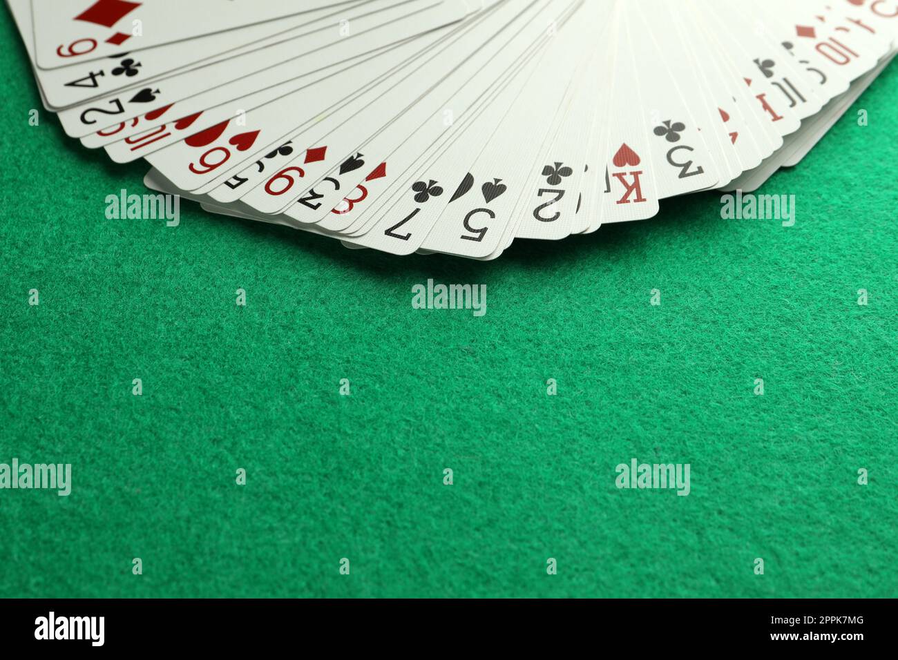 Fan of playing cards on green table. Space for text Stock Photo - Alamy