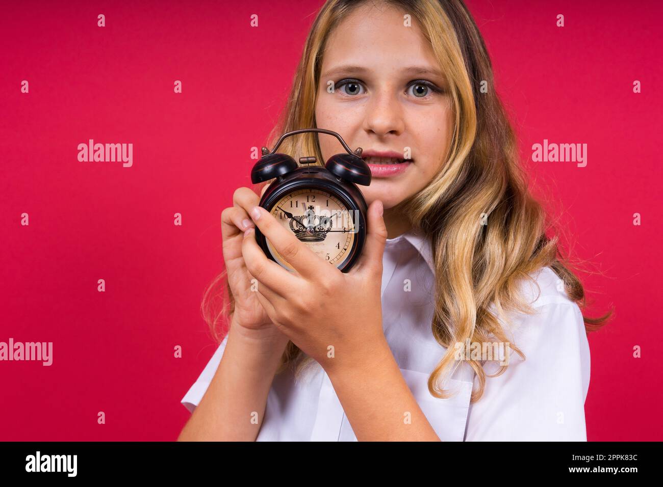 Young Girl holding an antique clock over red background Stock Photo - Alamy