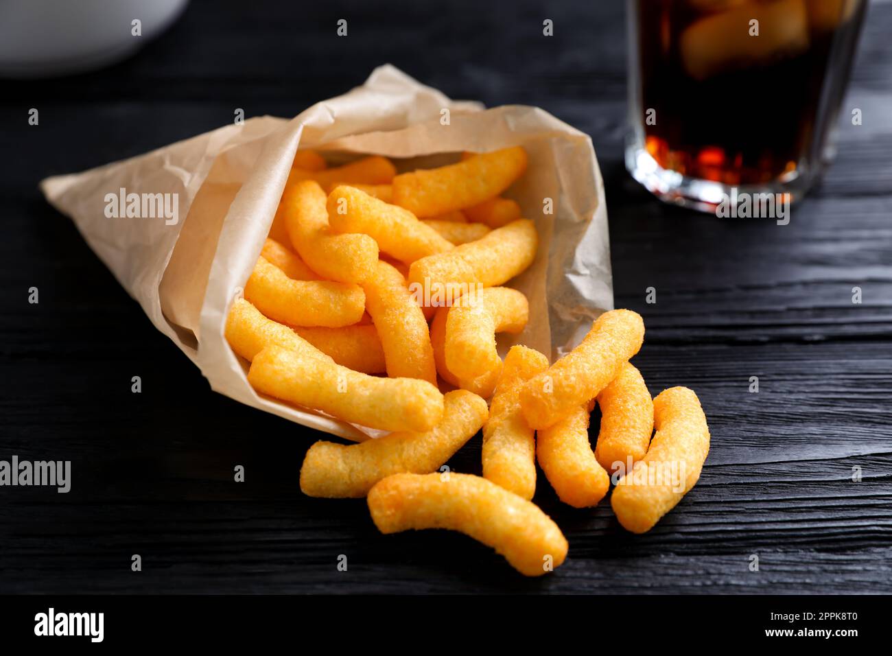 Crunchy cheesy corn snack on black wooden table, closeup Stock Photo ...