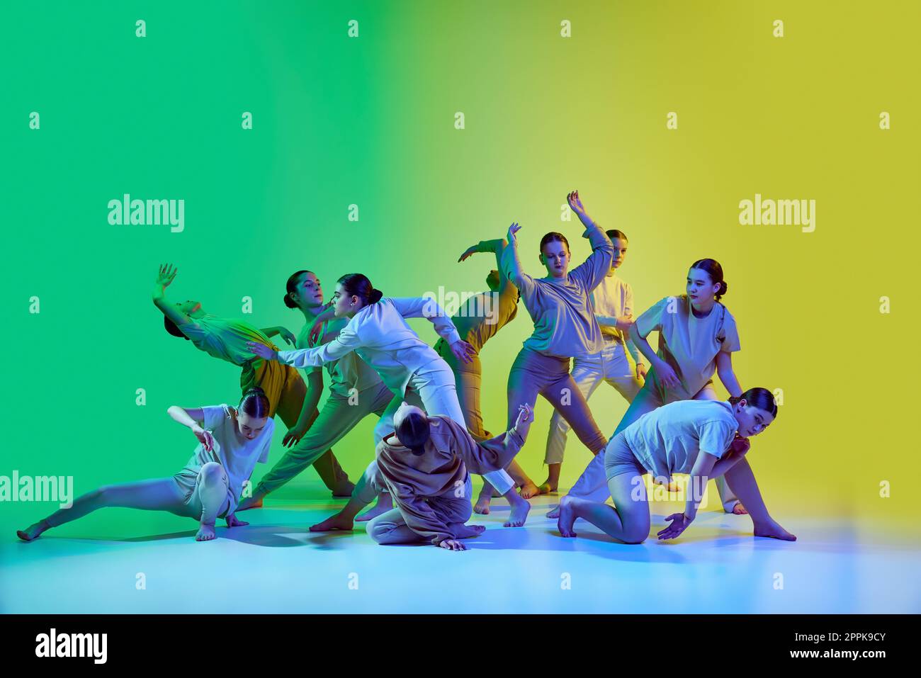 Group of young people dancing contemp against green and yellow gradient ...