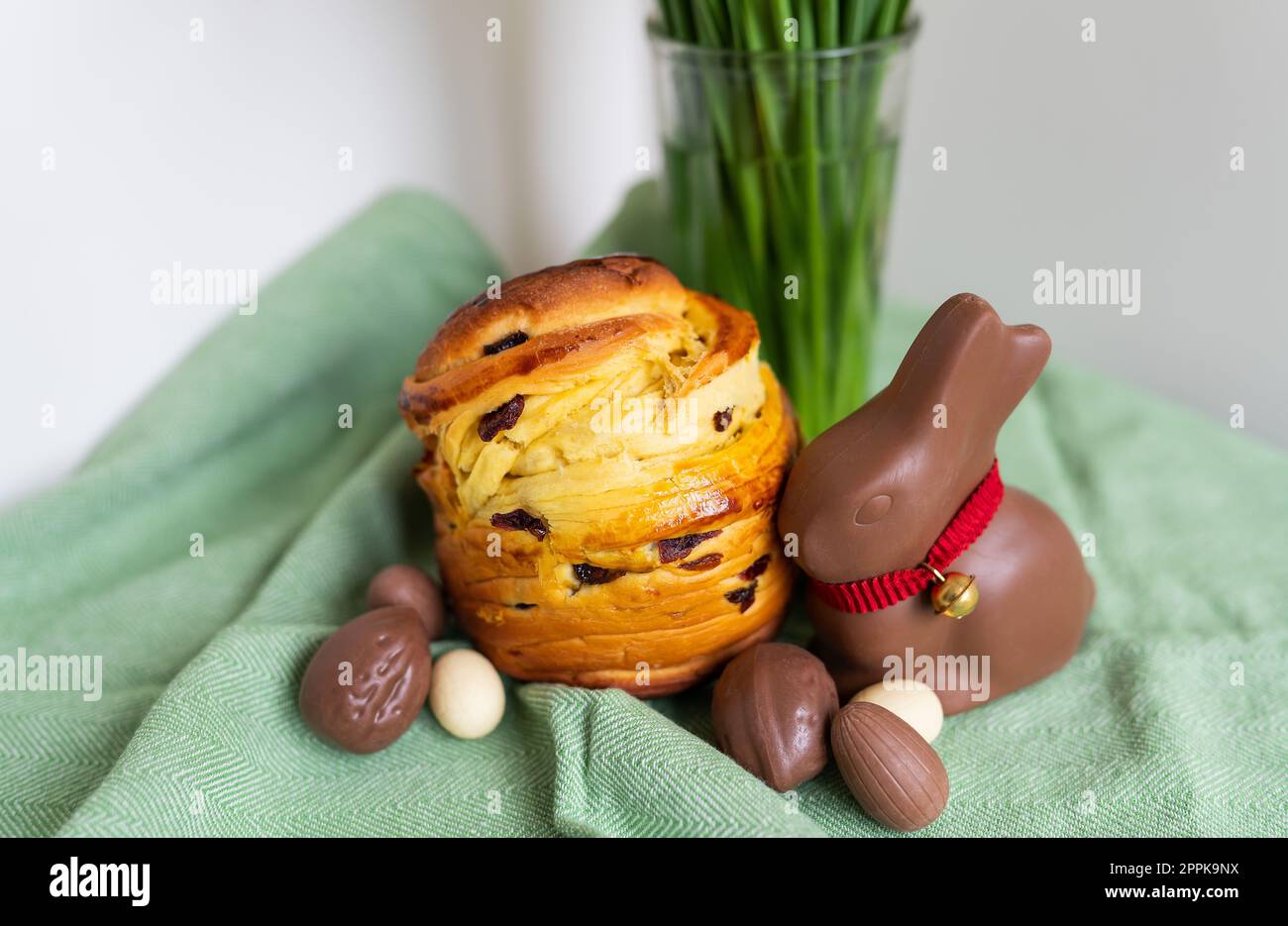 Homemade Easter traditional pastries lie on a green napkin with a bouquet of flowers, a rabbit ...