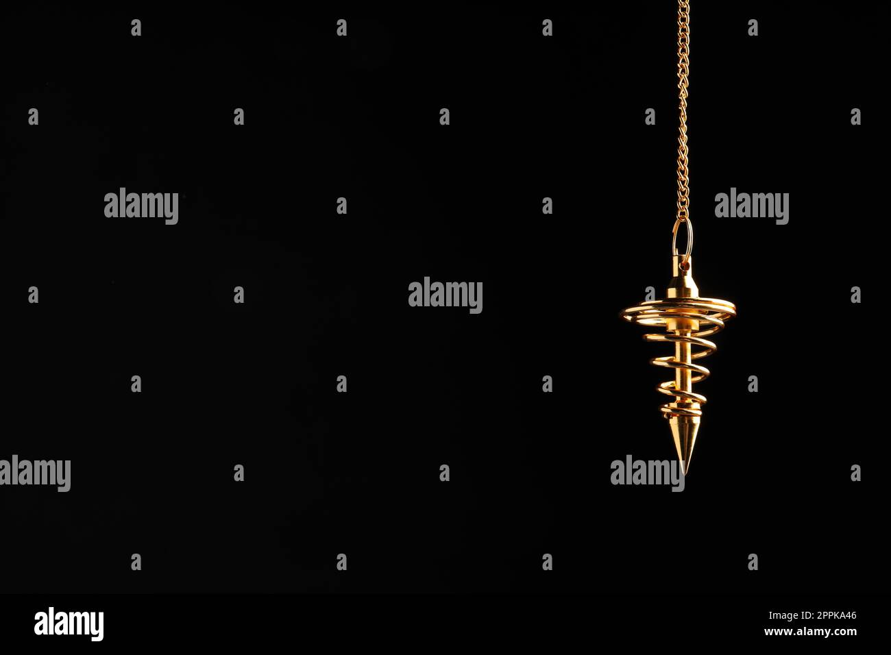 Beautiful golden pendulum with chain on black background, space for ...