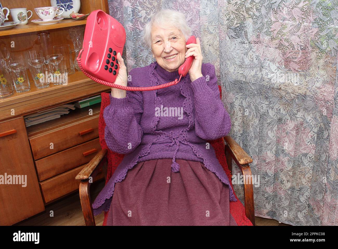 Happy senior woman using retro style landline phone at home Stock Photo ...