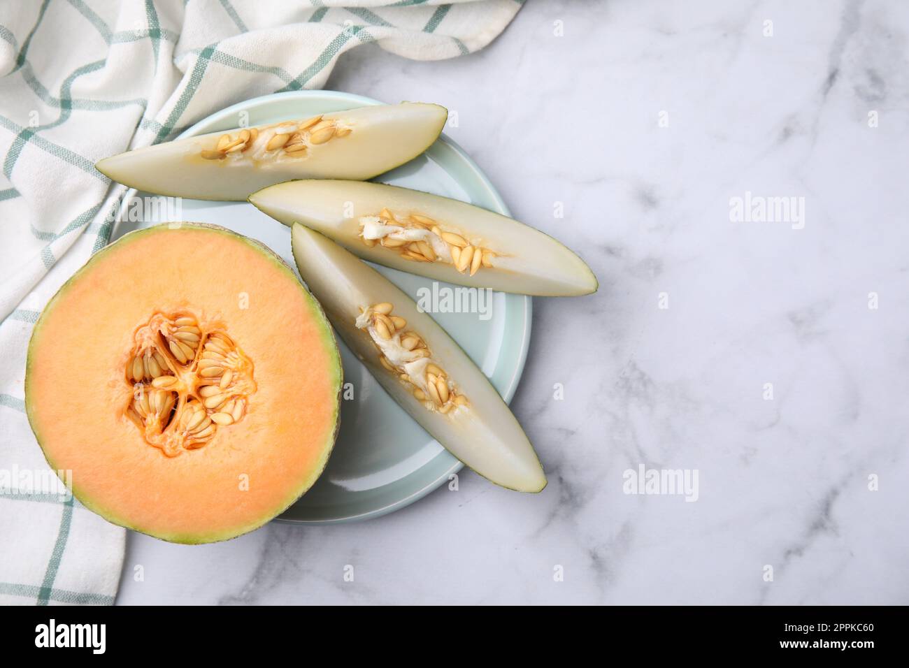 Tasty colorful ripe melons on white marble table, top view. Space for ...