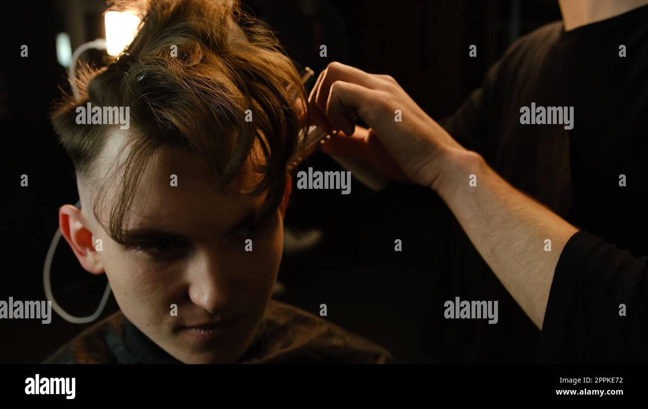 Close up Barber master hairdresser does hairstyle and style with ...