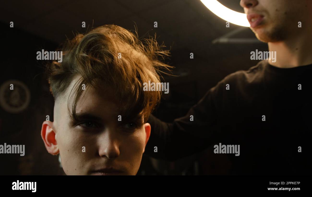 Barber shop. Man in barber's chair, hairdresser shaking hairs by the ...