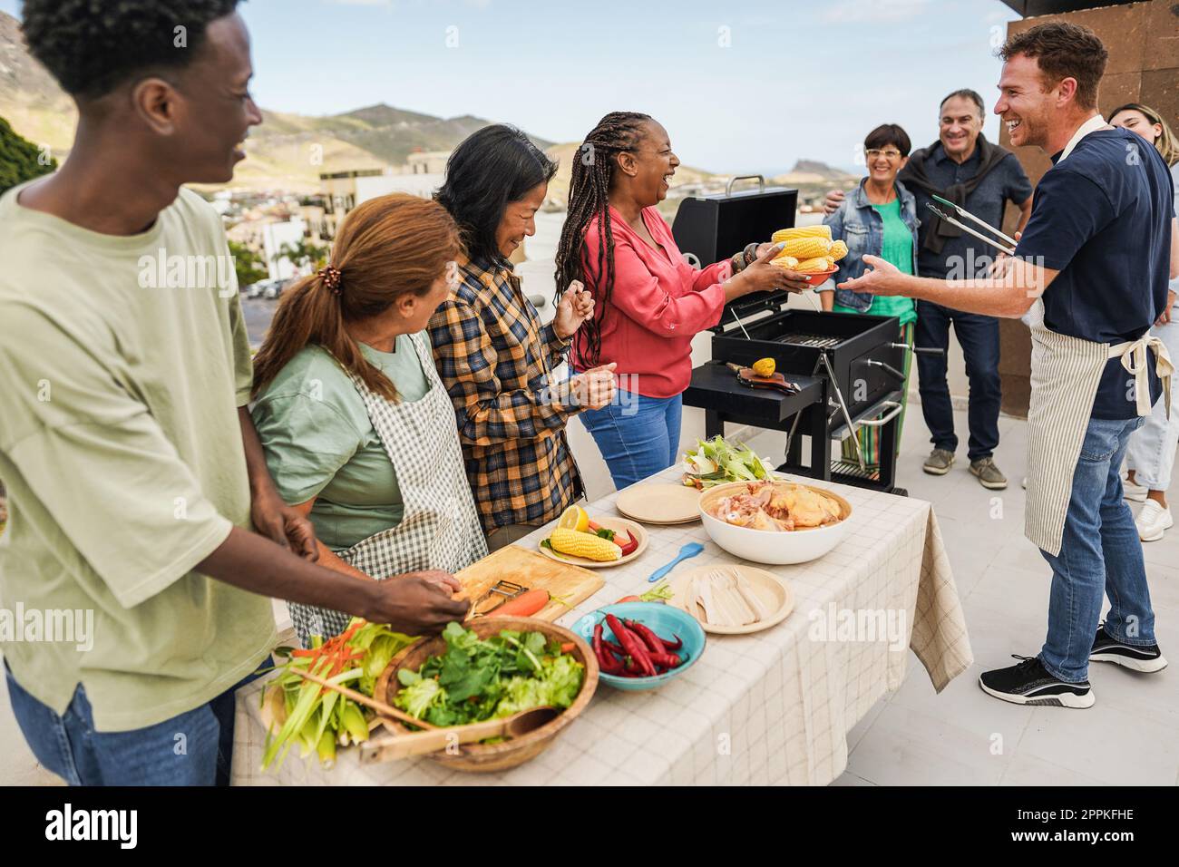 Multi generational people doing barbecue at home's rooftop ...