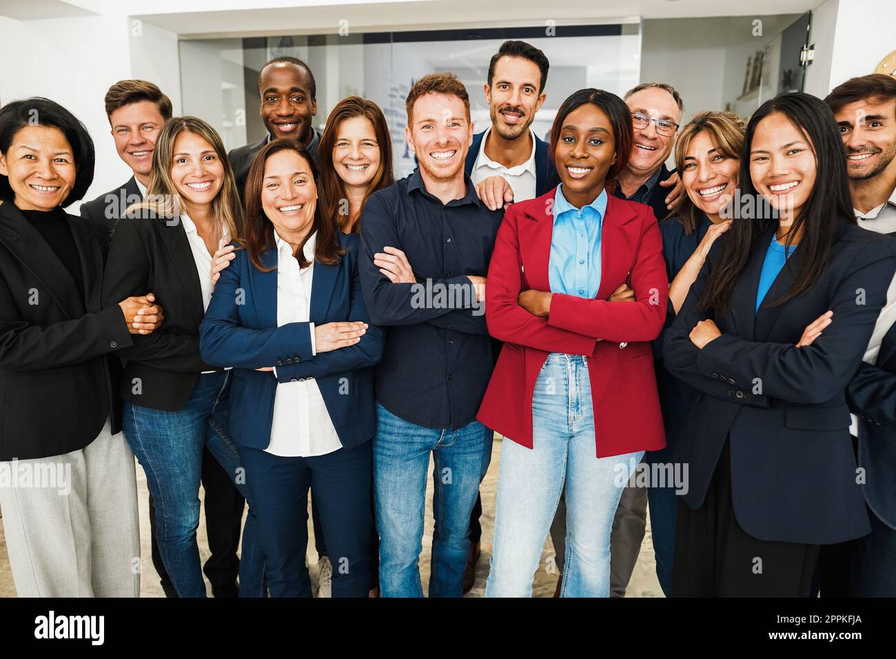 Multigenerational workers smiling in front of camera inside business ...