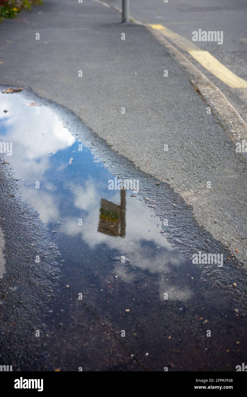 Bus stop sign reflecting in a rain puddle Stock Photo - Alamy