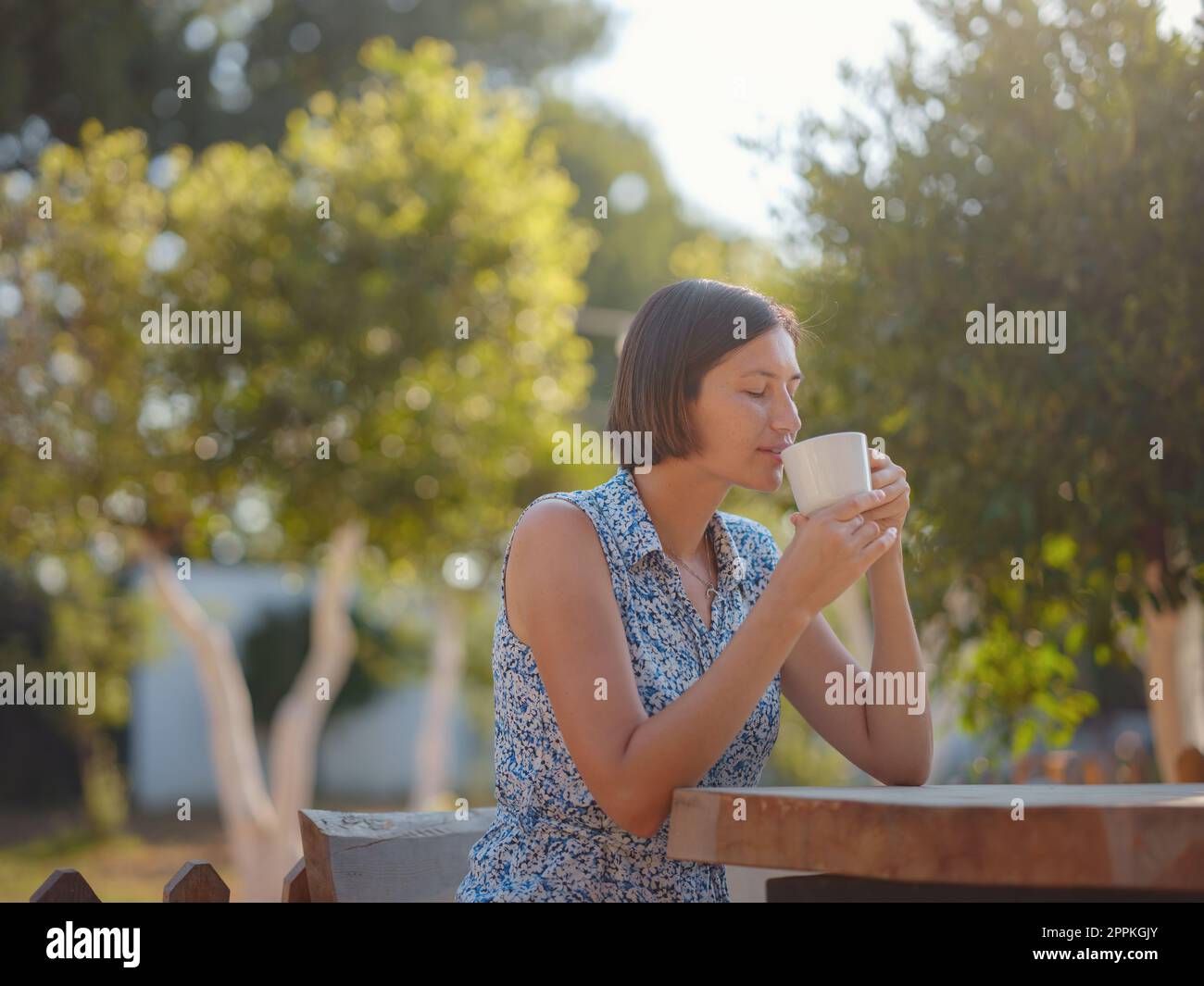 Woman is drinking coffee , morning routine near her Tiny house. First ...