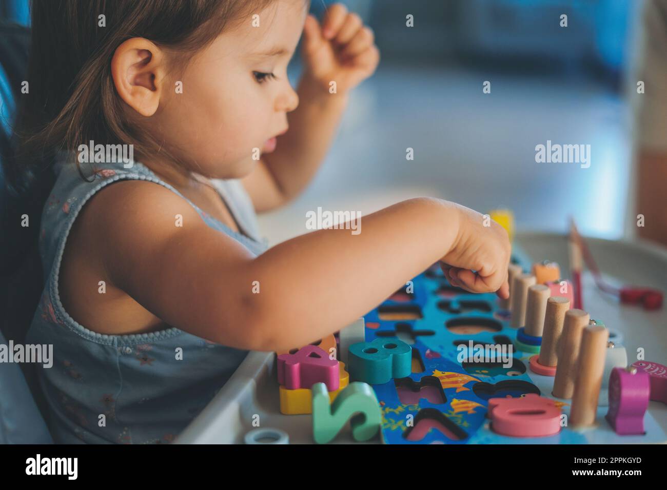 Side view of a baby girl learning numbers through gam, activity with ...