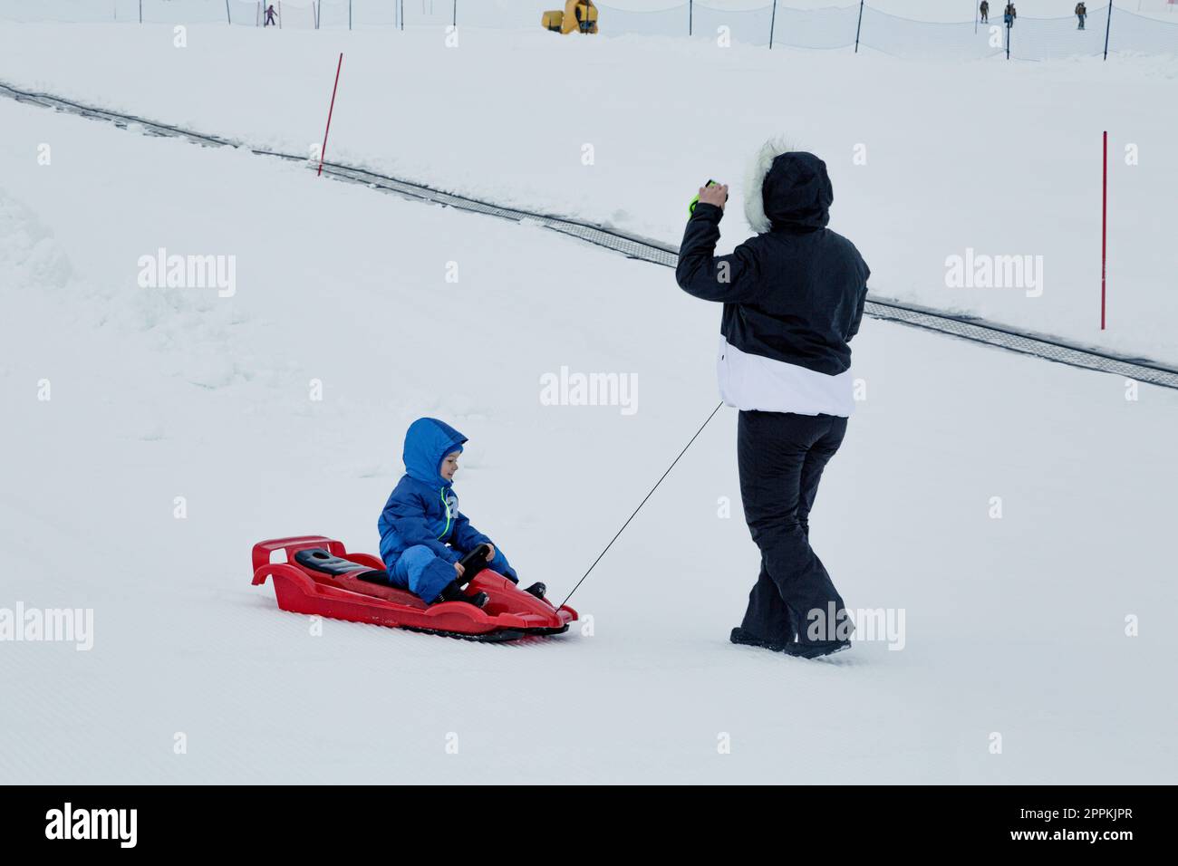 Children sled in the Alps mountains in winter Stock Photo - Alamy