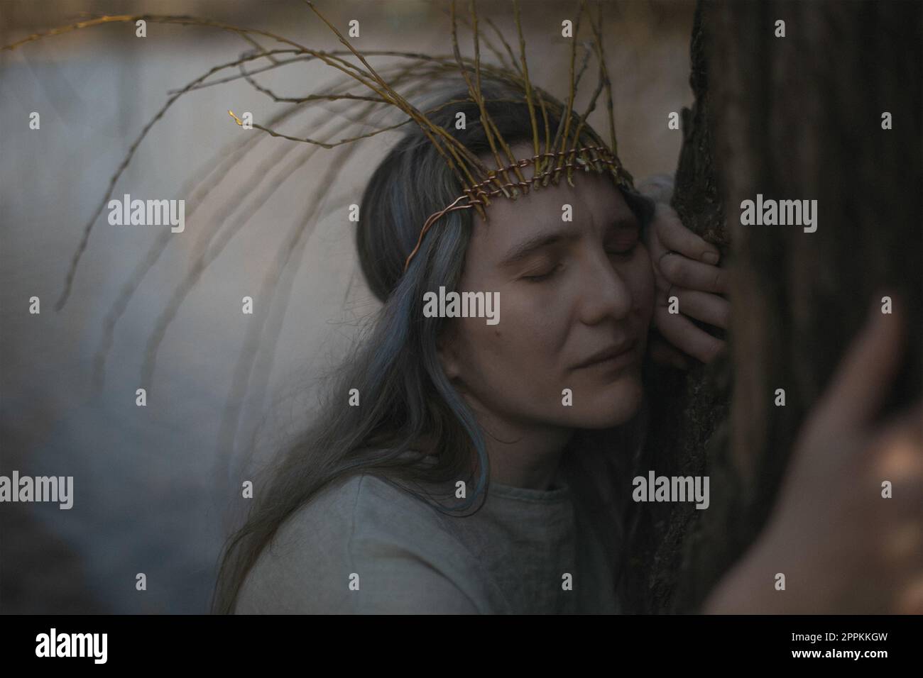Close up ancient celtic styled woman hugging tree and praying portrait ...