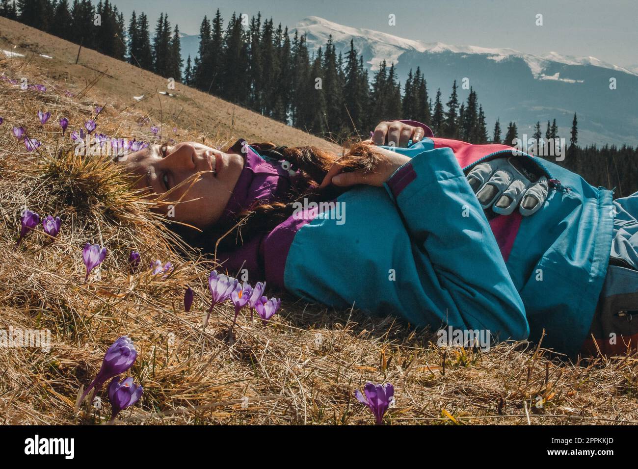 Close up female hiker lying among dried grass and flowers on hill ...