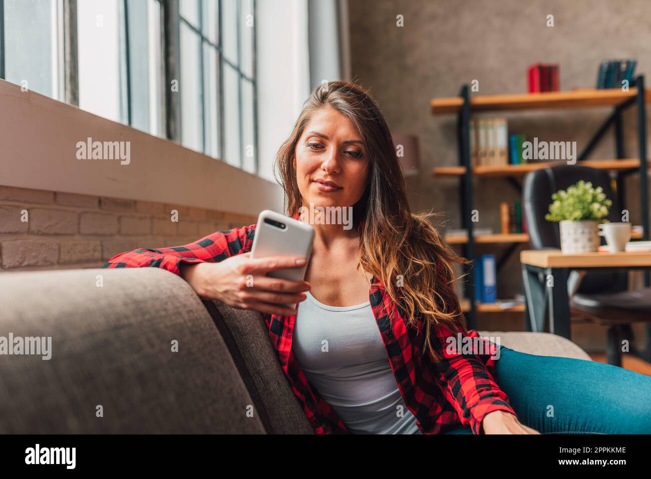 Woman relax at home in her free time with mobile phone Stock Photo - Alamy