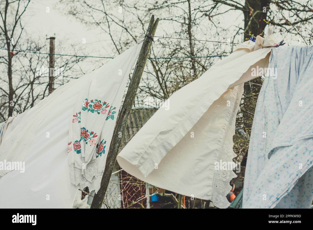 Close up fresh washed clothes on clothesline waving in wind concept ...