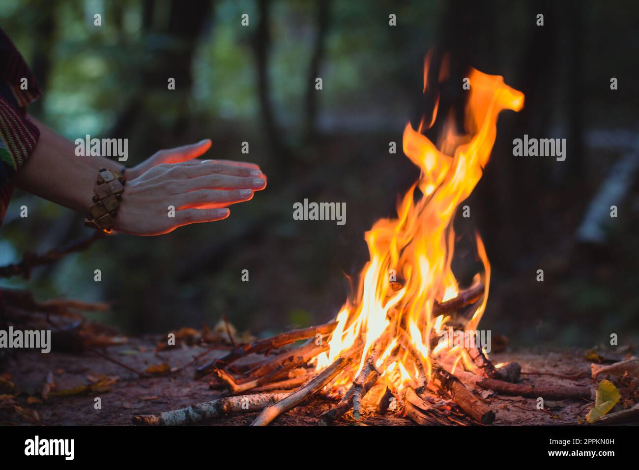 Close up hands warming over campfire concept photo Stock Photo - Alamy