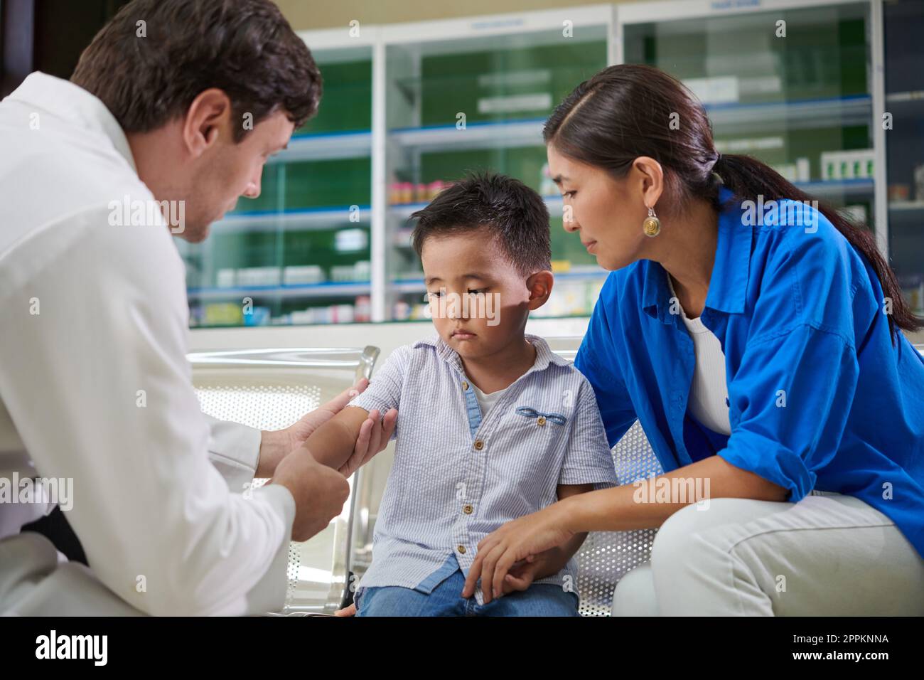 Surgeon palpating arm of little boy checking of fracture healed Stock ...