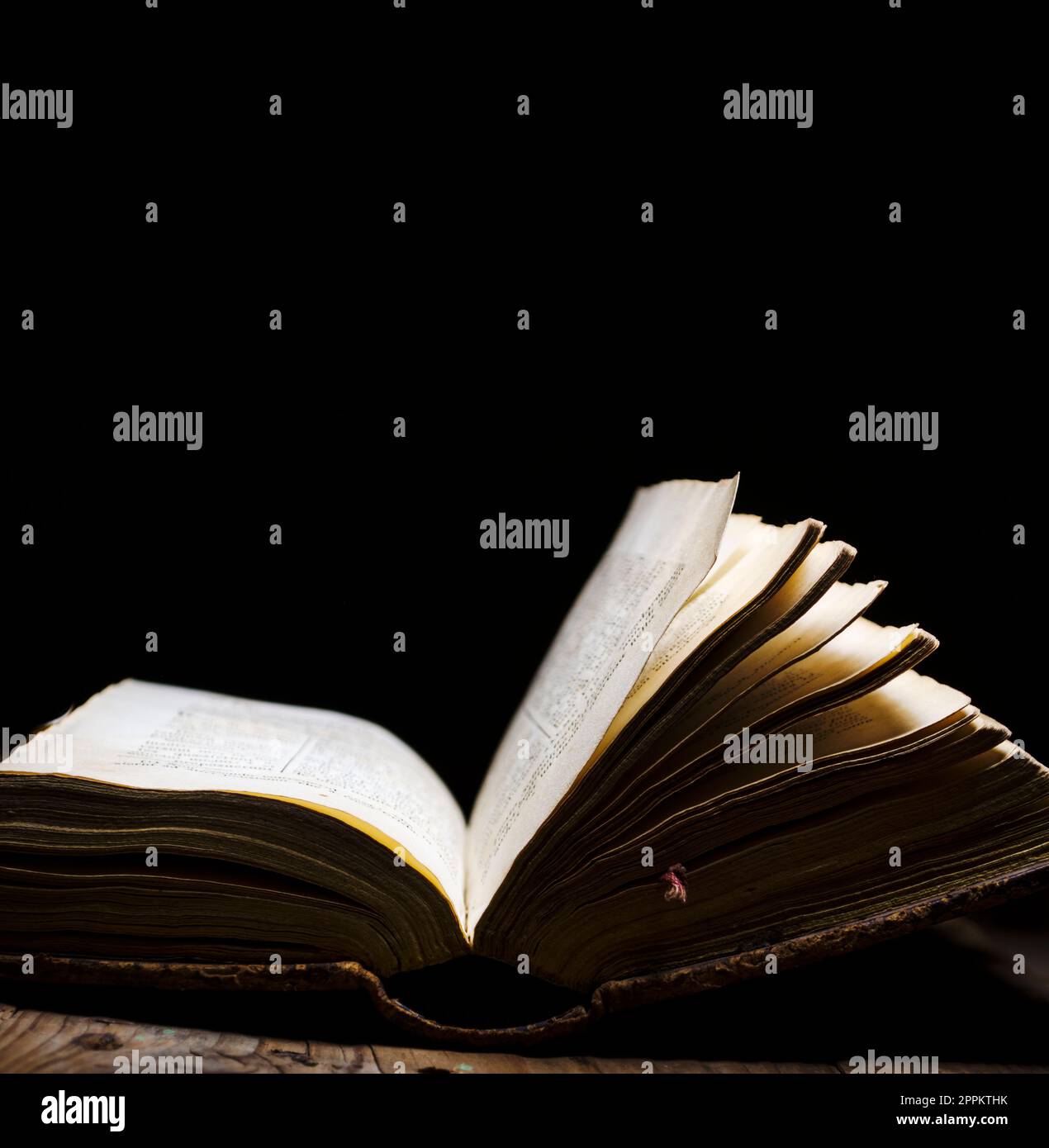 Old book open on vintage table on dark background Stock Photo - Alamy