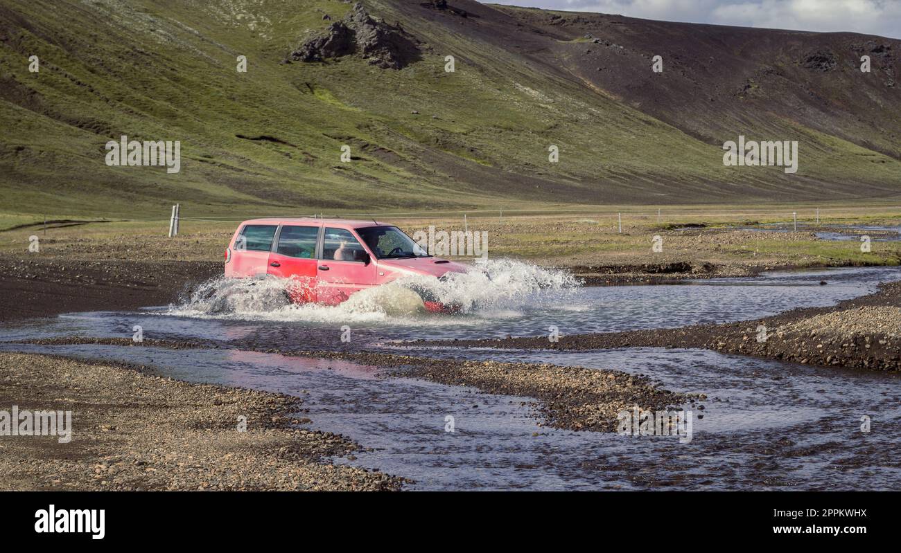 Red cars driving across mountain river landscape photo Stock Photo - Alamy