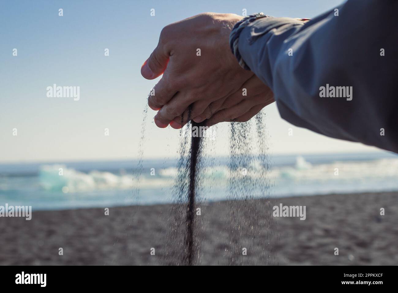 Close up sand pouring out of male palms concept photo Stock Photo - Alamy