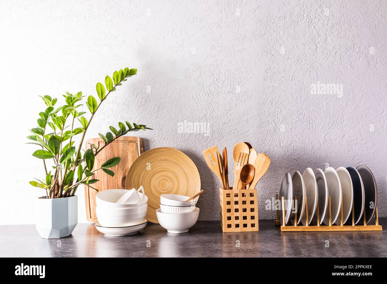 a set of various kitchen utensils and tools, ceramic dishes in light ...