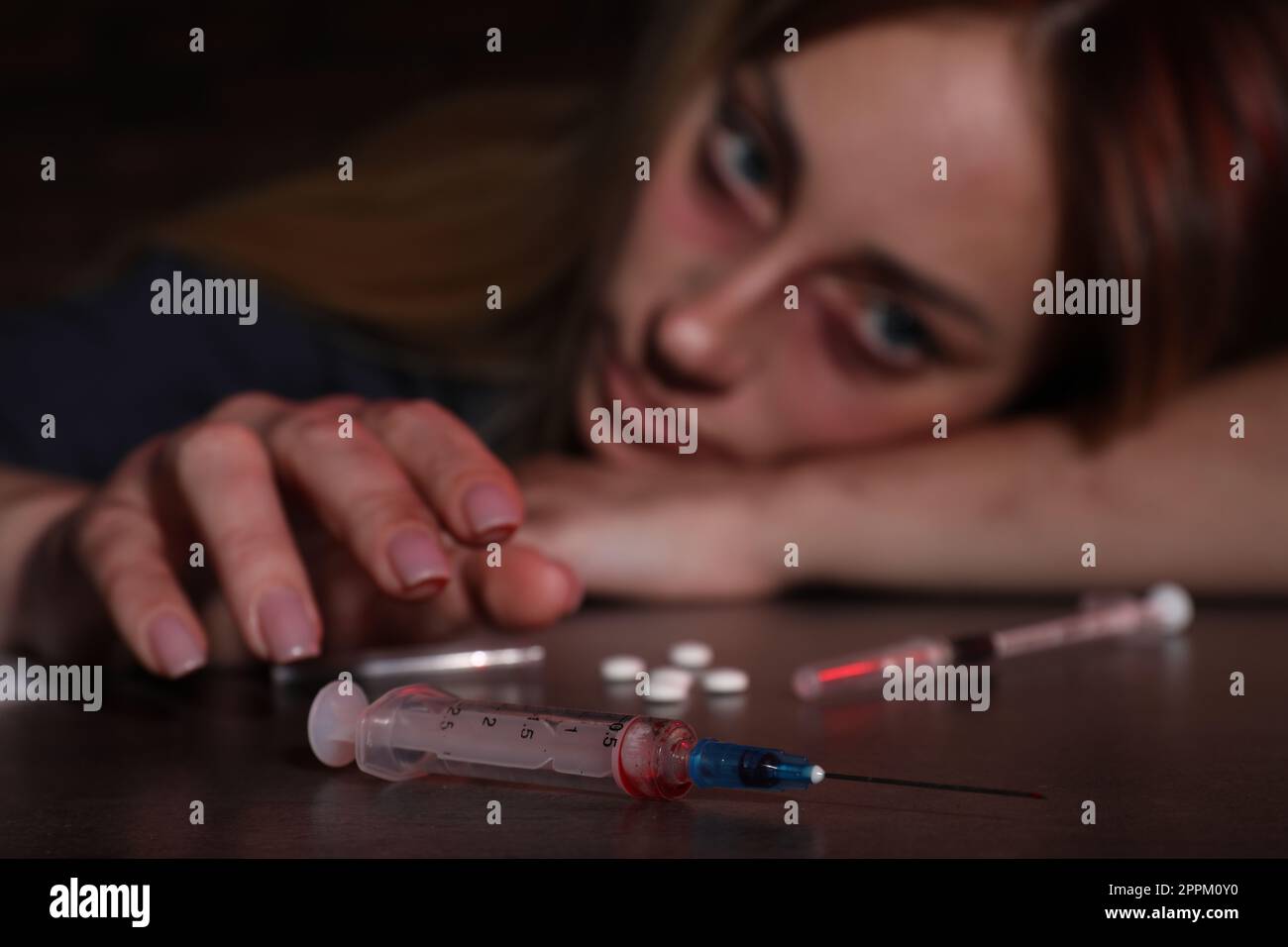 Addicted woman at table, focus on different drugs Stock Photo - Alamy
