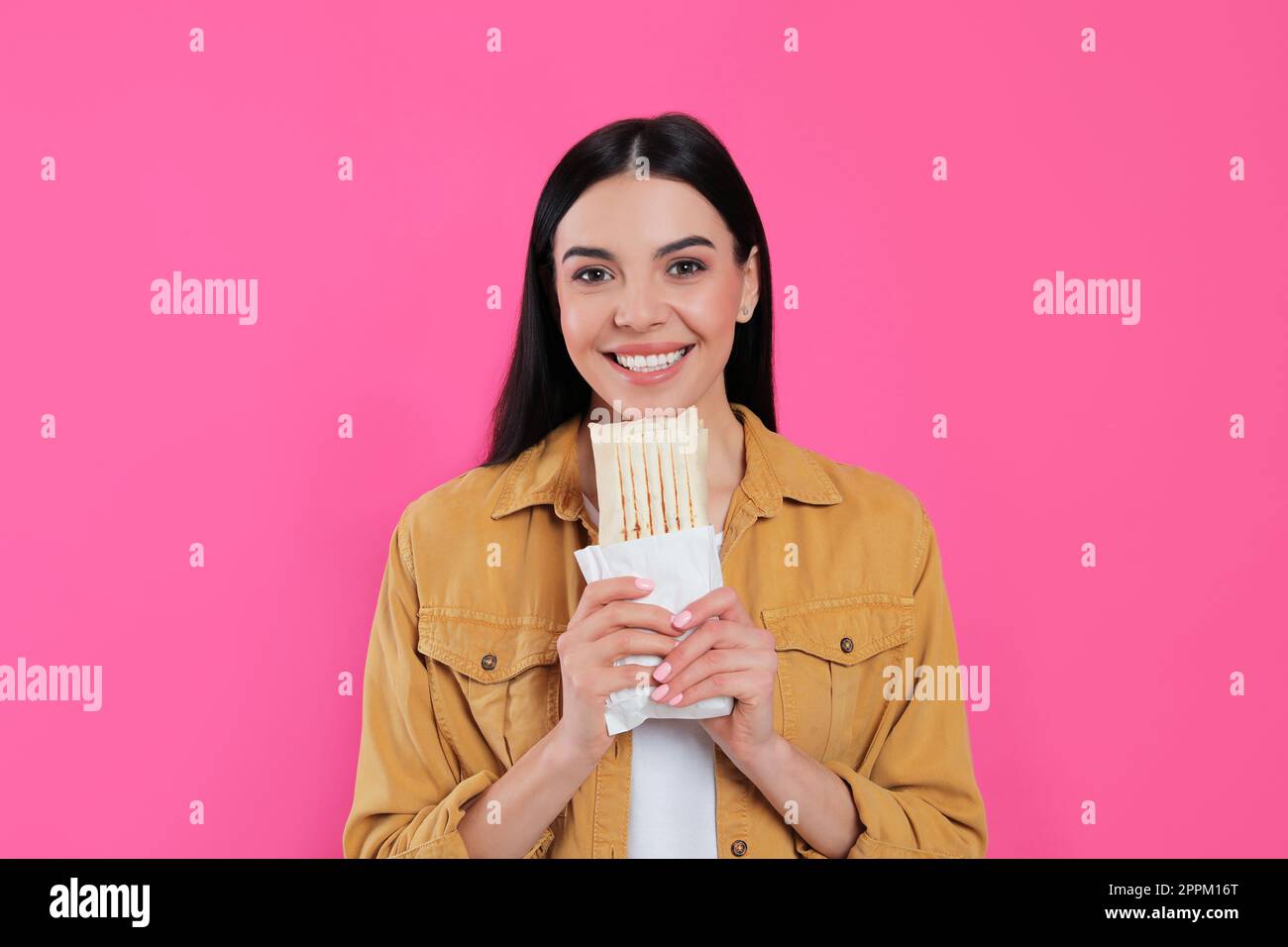 Happy young woman with delicious shawarma on pink background Stock ...