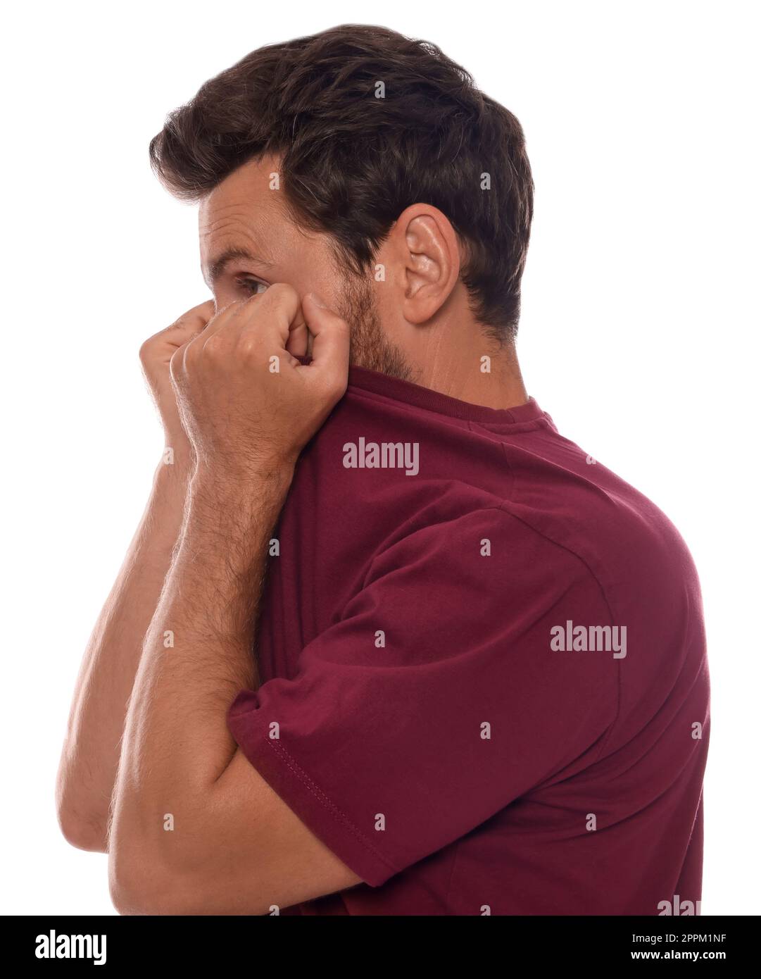Man covering face with shirt on white background Stock Photo - Alamy