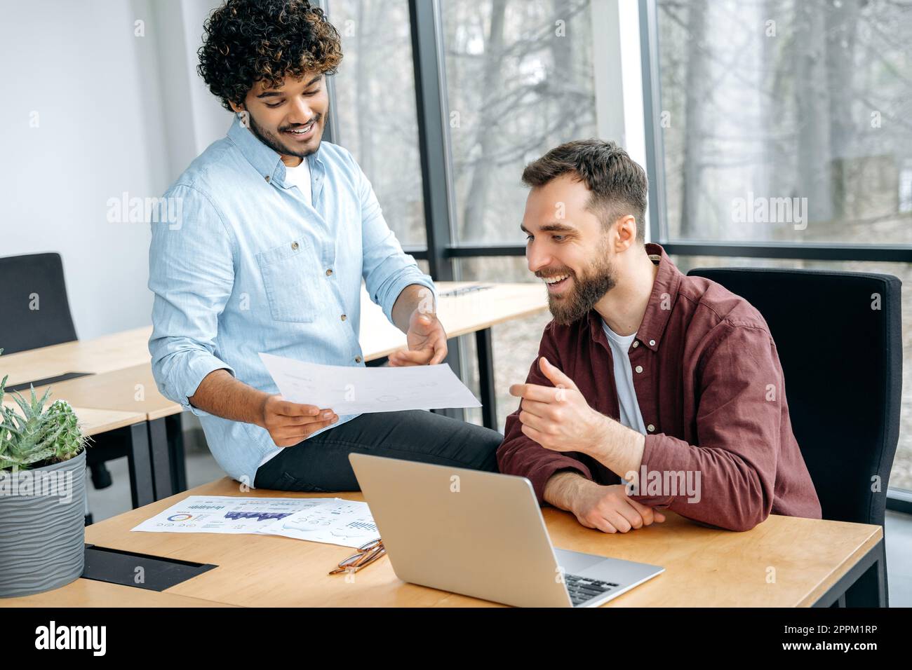 Positive successful male business partners of different nationalities ...