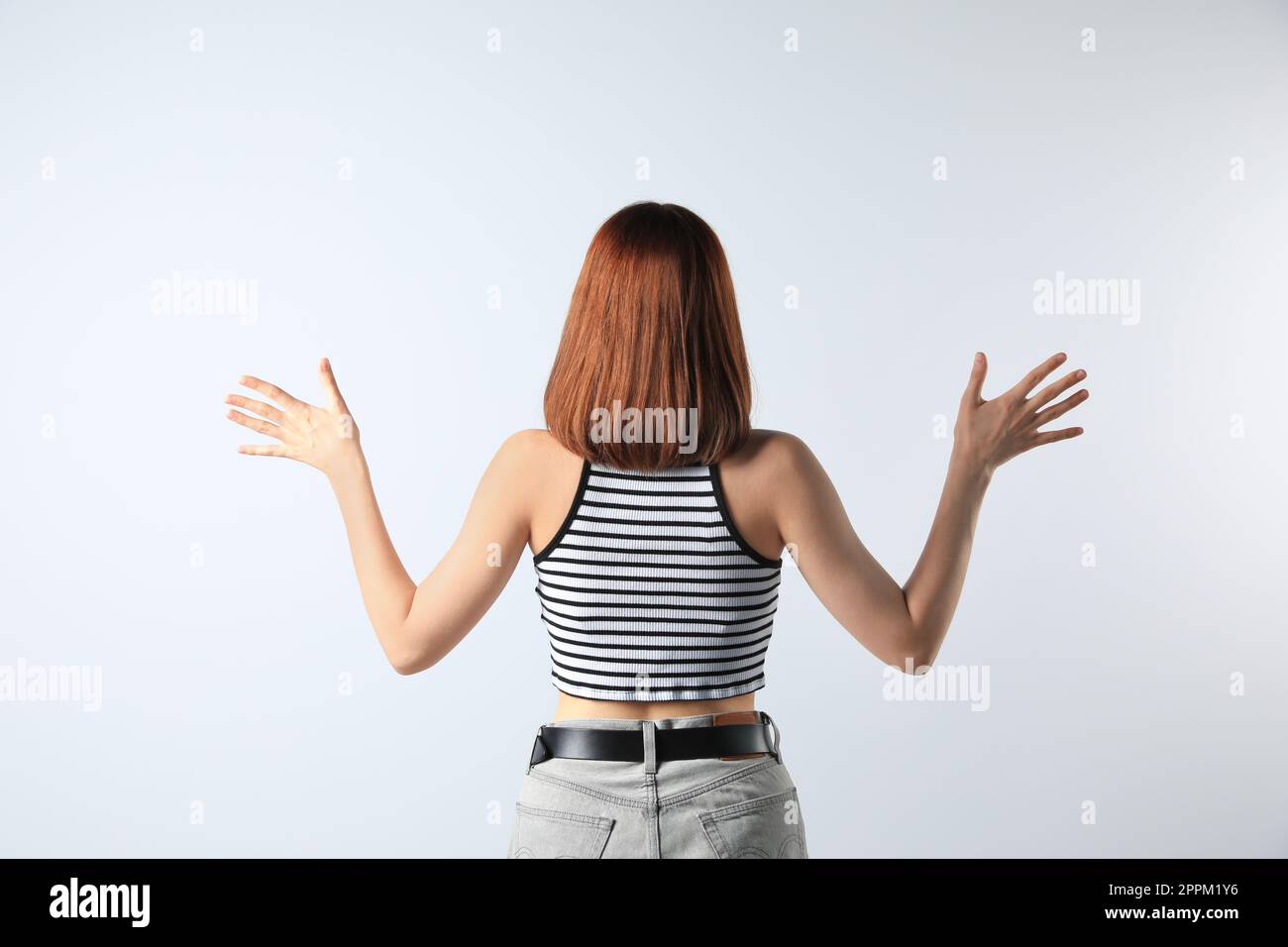 Girl wearing striped top on white background, back view Stock Photo - Alamy