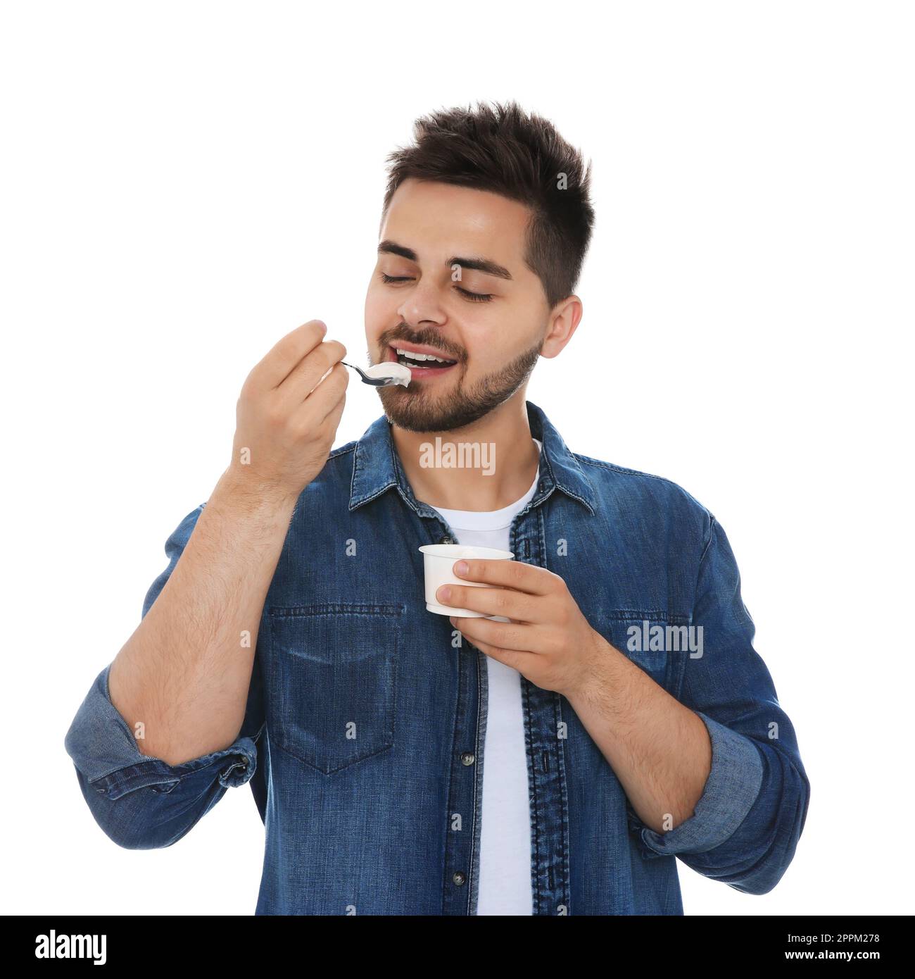 Young man eating yoghurt hi-res stock photography and images - Alamy