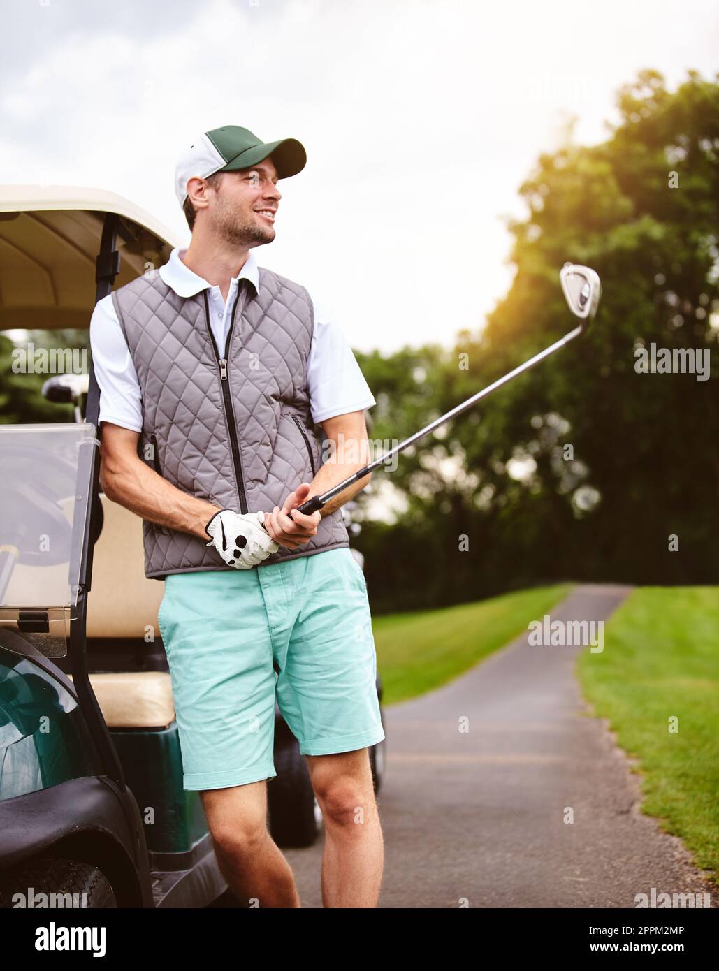 Hes ready for some golf. a handsome young man leaning against a golf ...