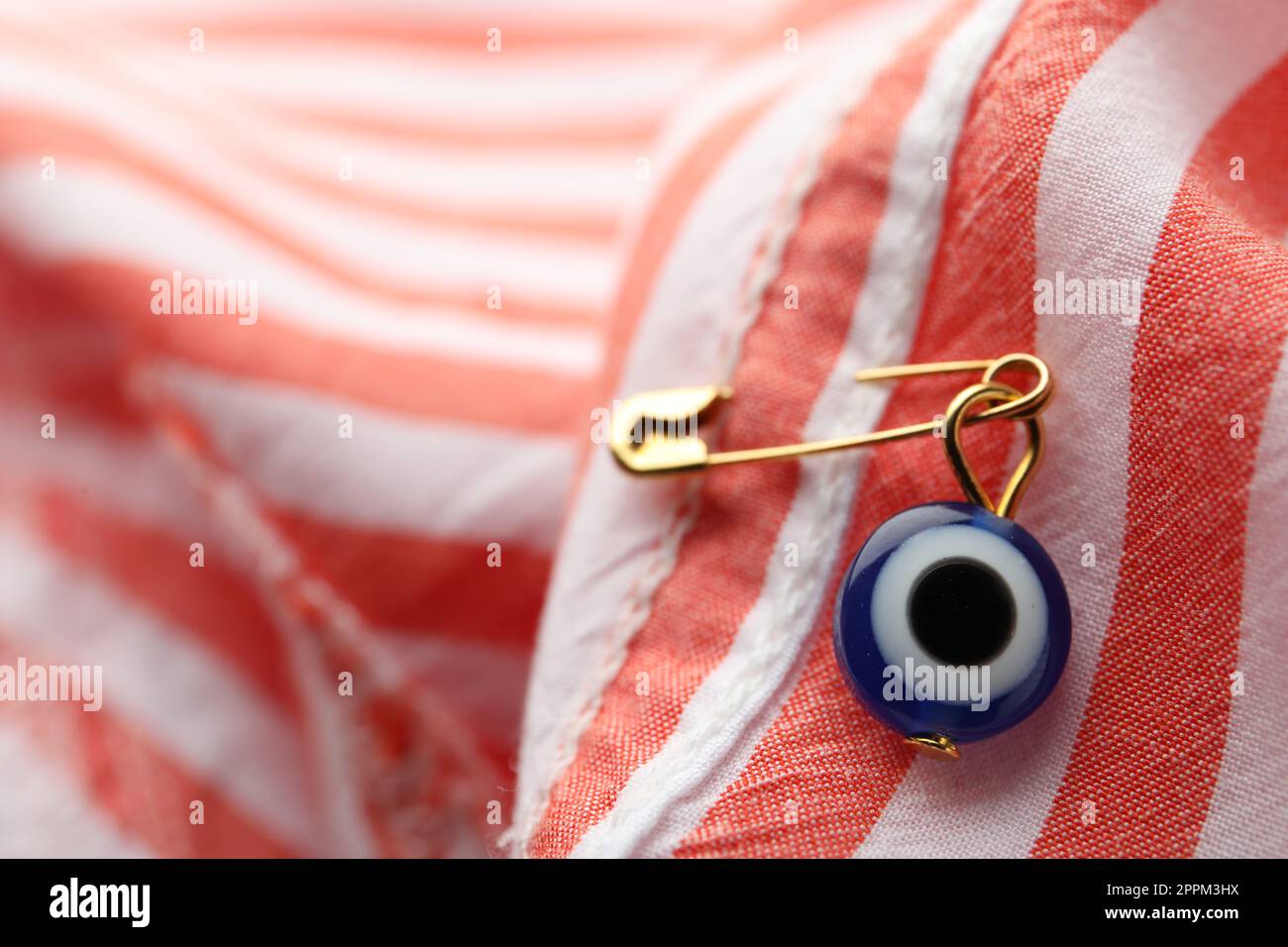 Evil eye safety pin on clothing, closeup Stock Photo - Alamy