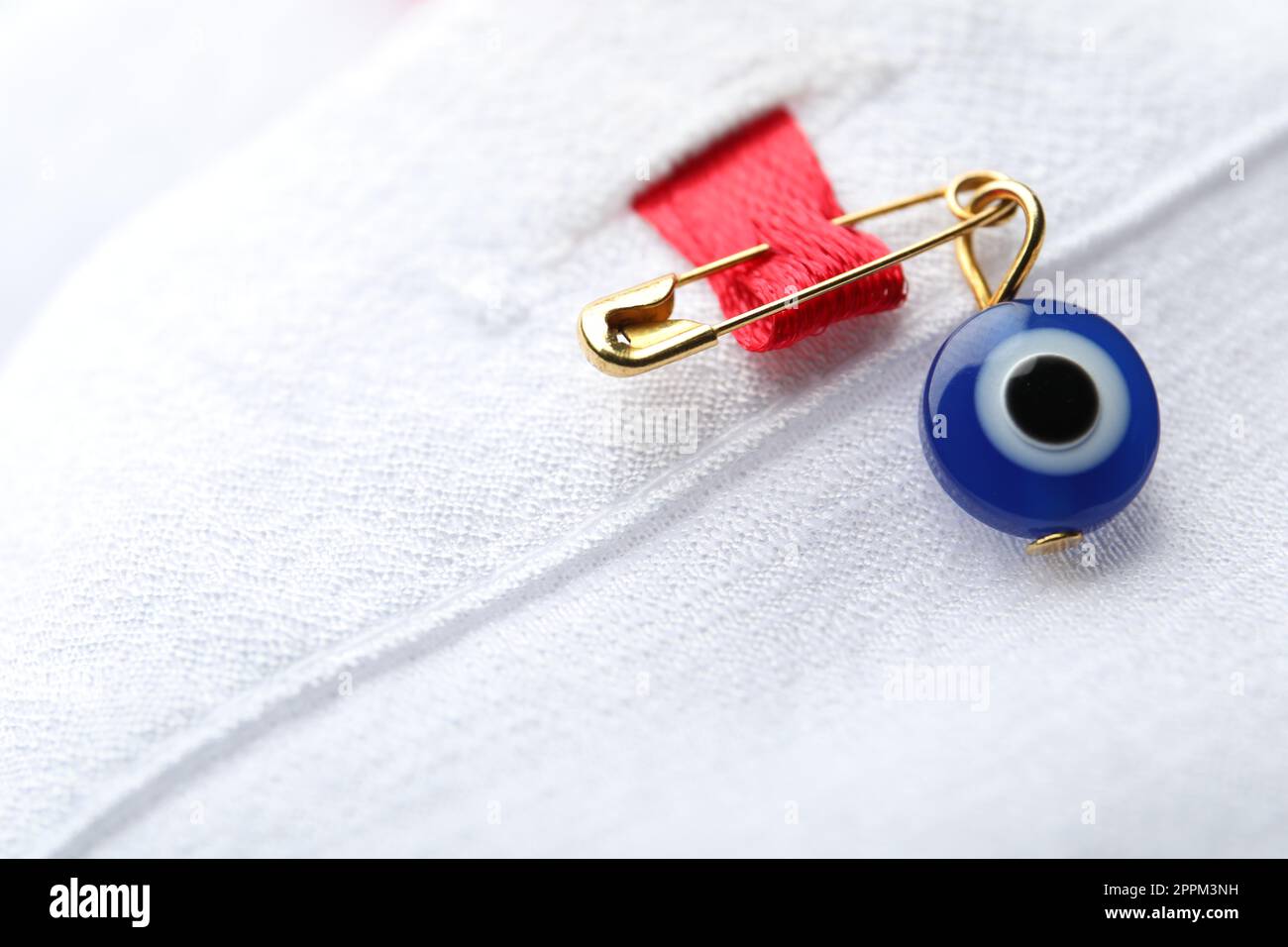 Evil eye safety pin on clothing, closeup Stock Photo - Alamy