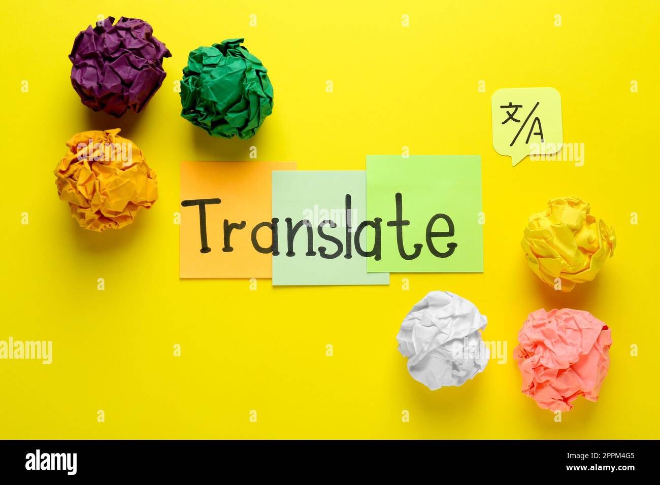 Word Translate made with sticky notes near crumpled paper balls on ...