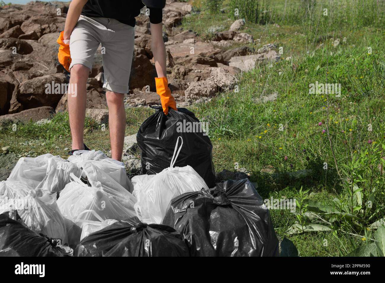 Man with trash bags full of garbage outdoors, closeup. Environmental ...