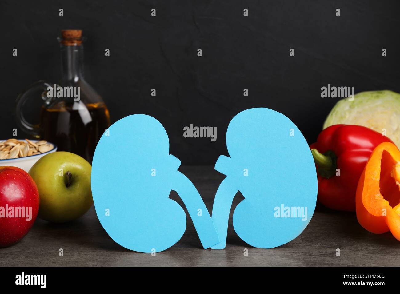 Paper cutout of kidneys and different products on grey table against ...