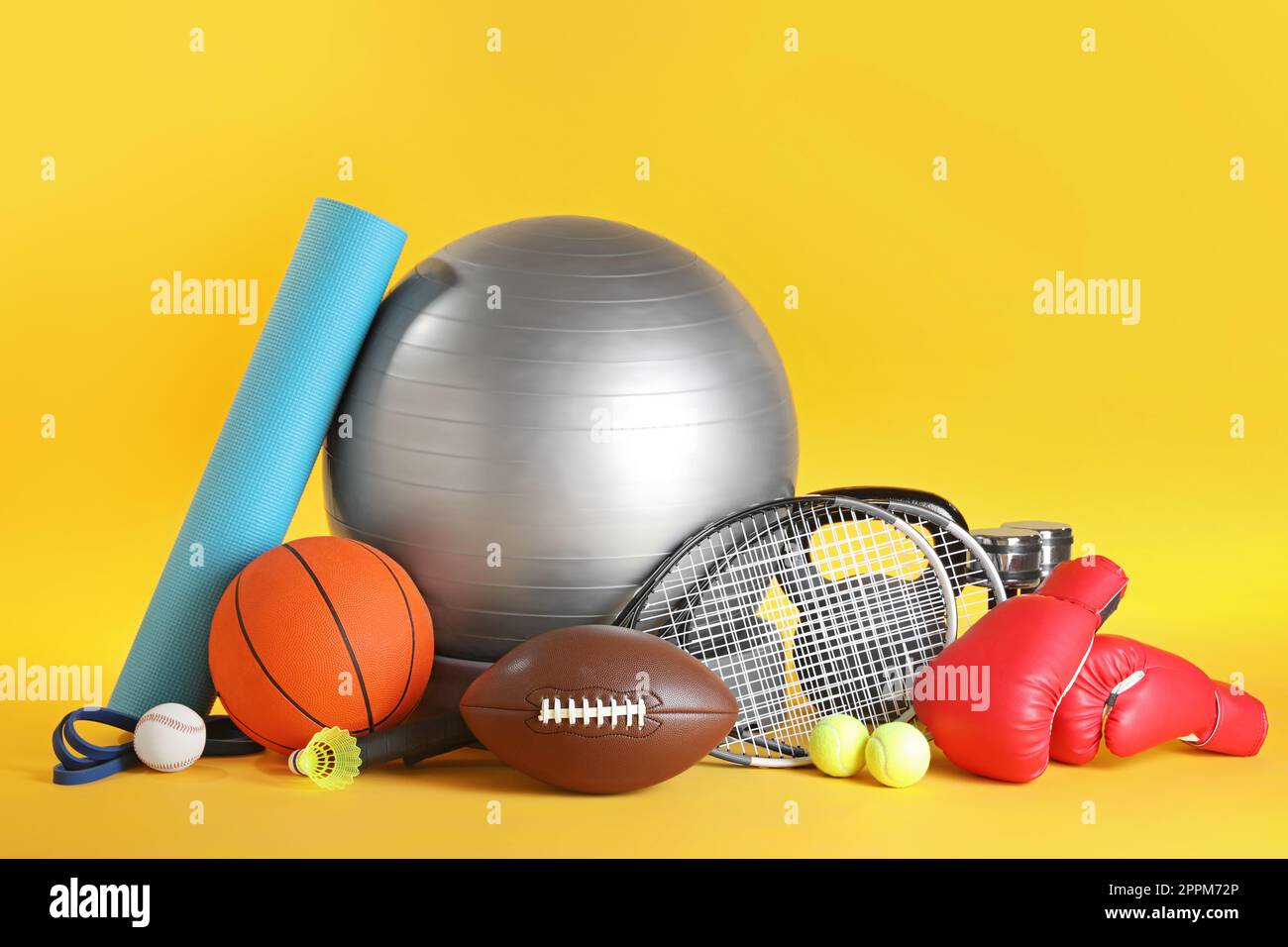 Set of different sports equipment on yellow background Stock Photo - Alamy
