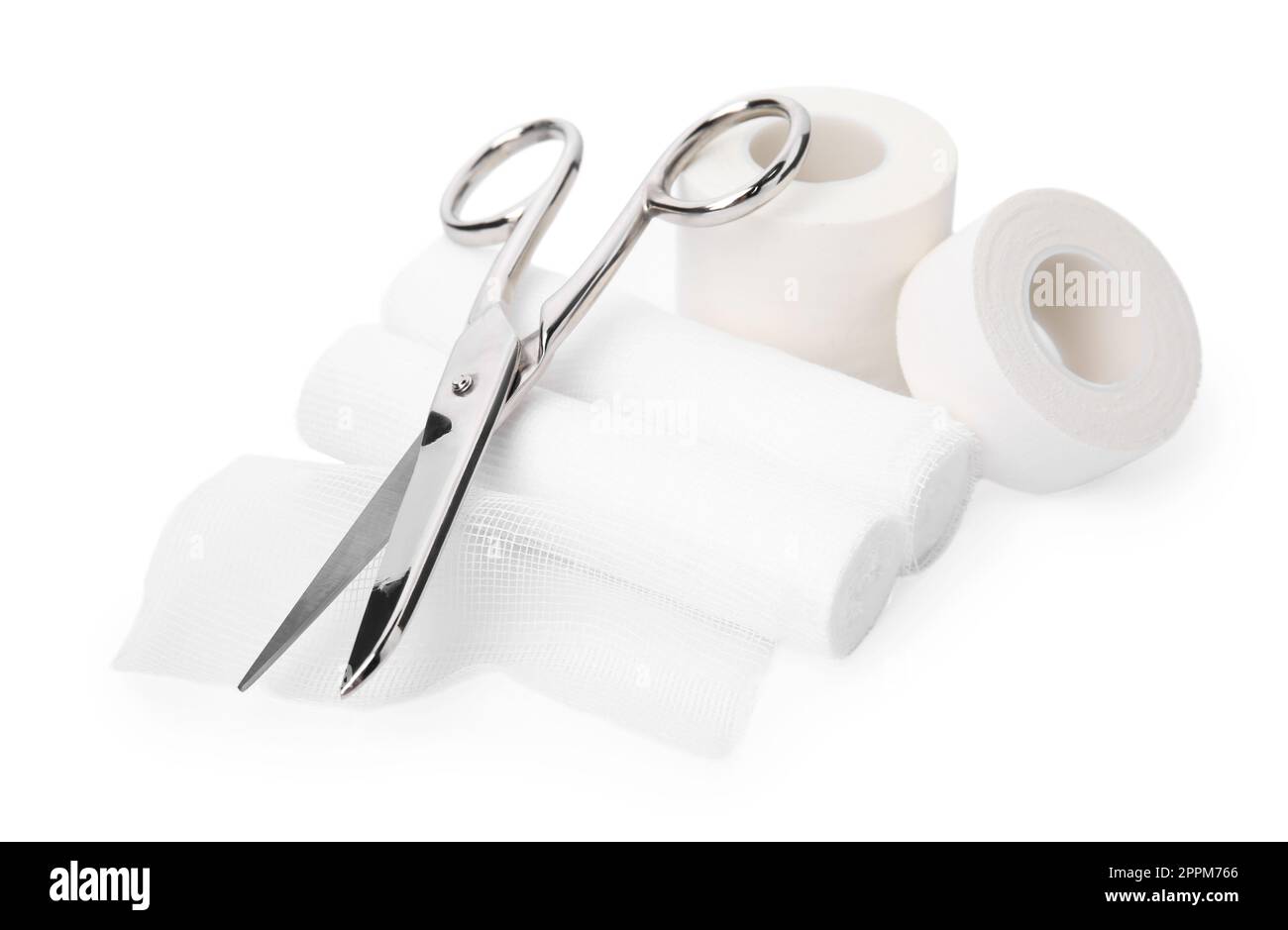 Medical bandage rolls, sticking plaster and scissors on white ...