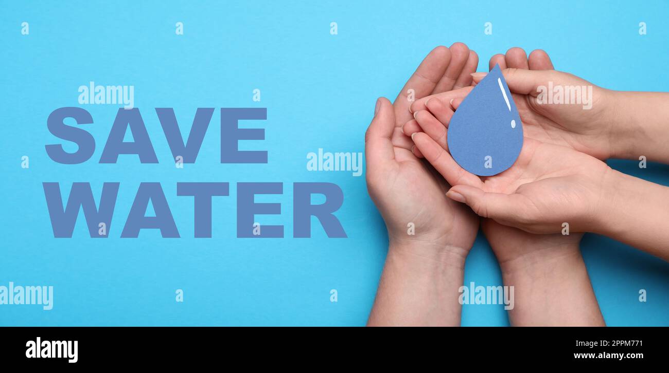 Save Water concept. Man and woman holding paper drop on light blue ...