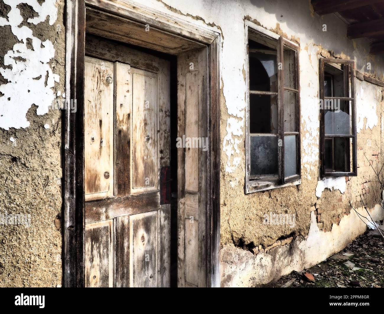 Old house with windows and a door. Collapsing rural house. The concept ...