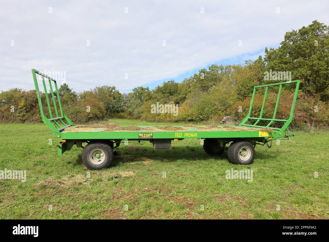 Trailer for transporting hay bales in a meadow Stock Photo - Alamy