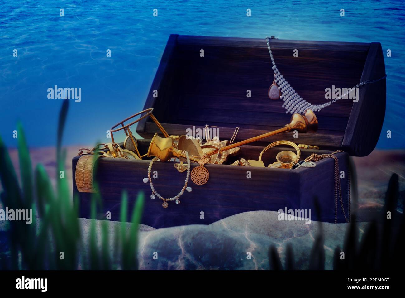 Open wooden chest full of treasures on sand seabed Stock Photo - Alamy