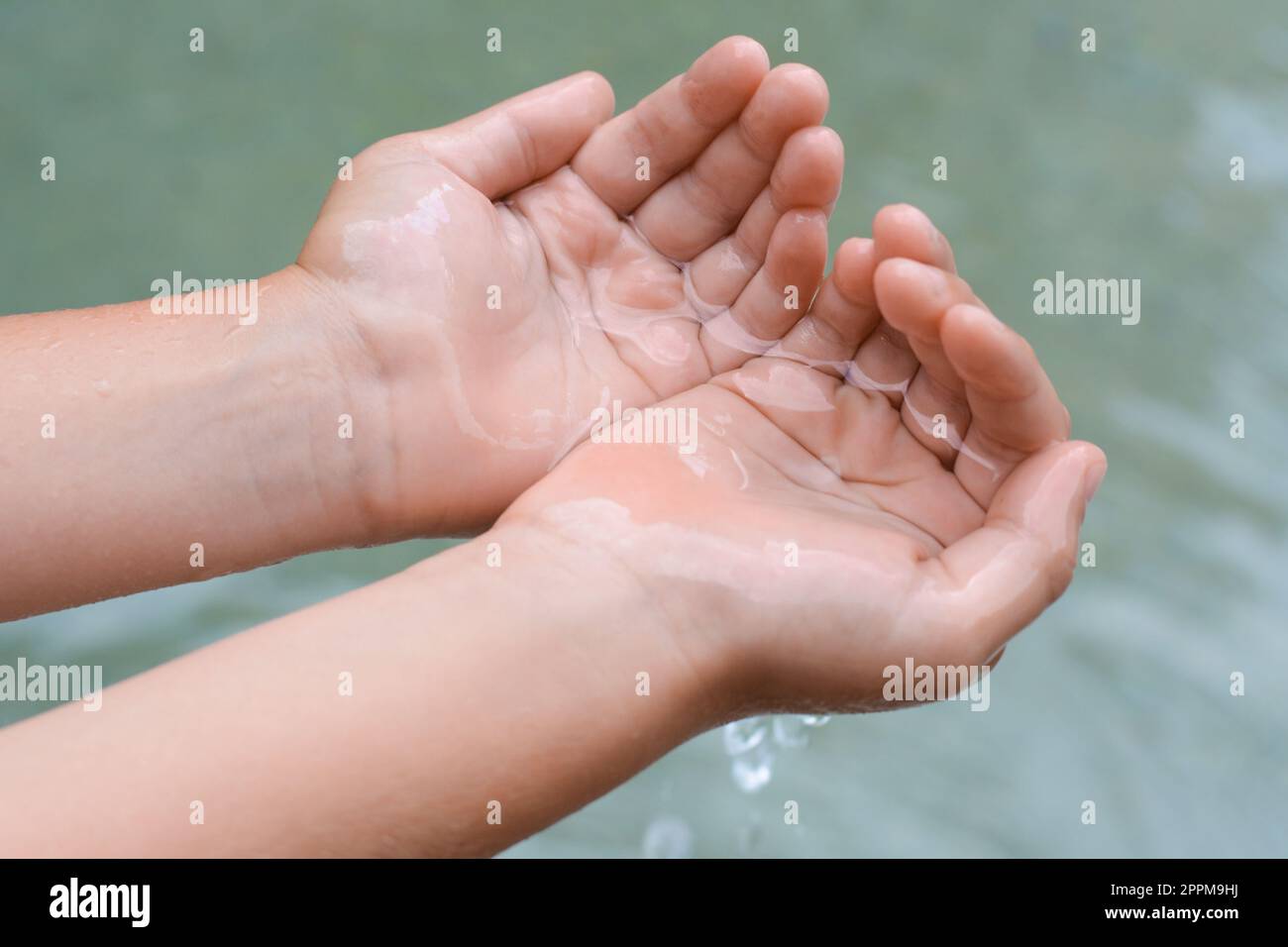 Kid holding water in hands above sea outdoors, closeup Stock Photo - Alamy